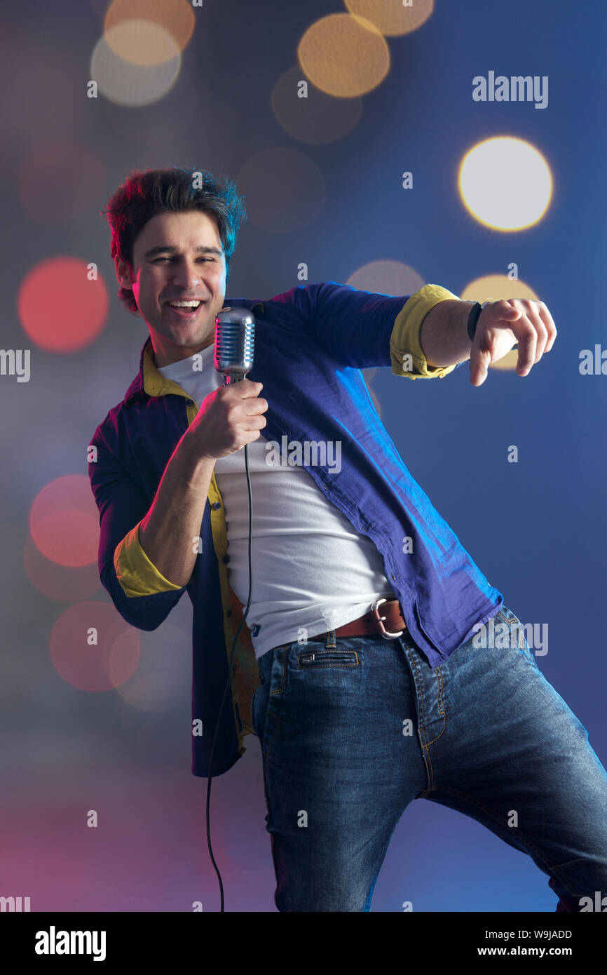 Man singing into microphone and dancing Stock Photo - Alamy