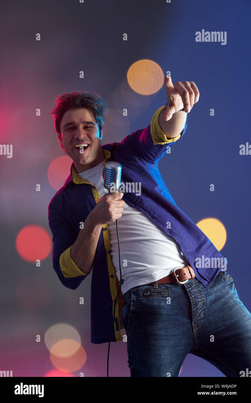 Man singing into microphone and dancing Stock Photo - Alamy