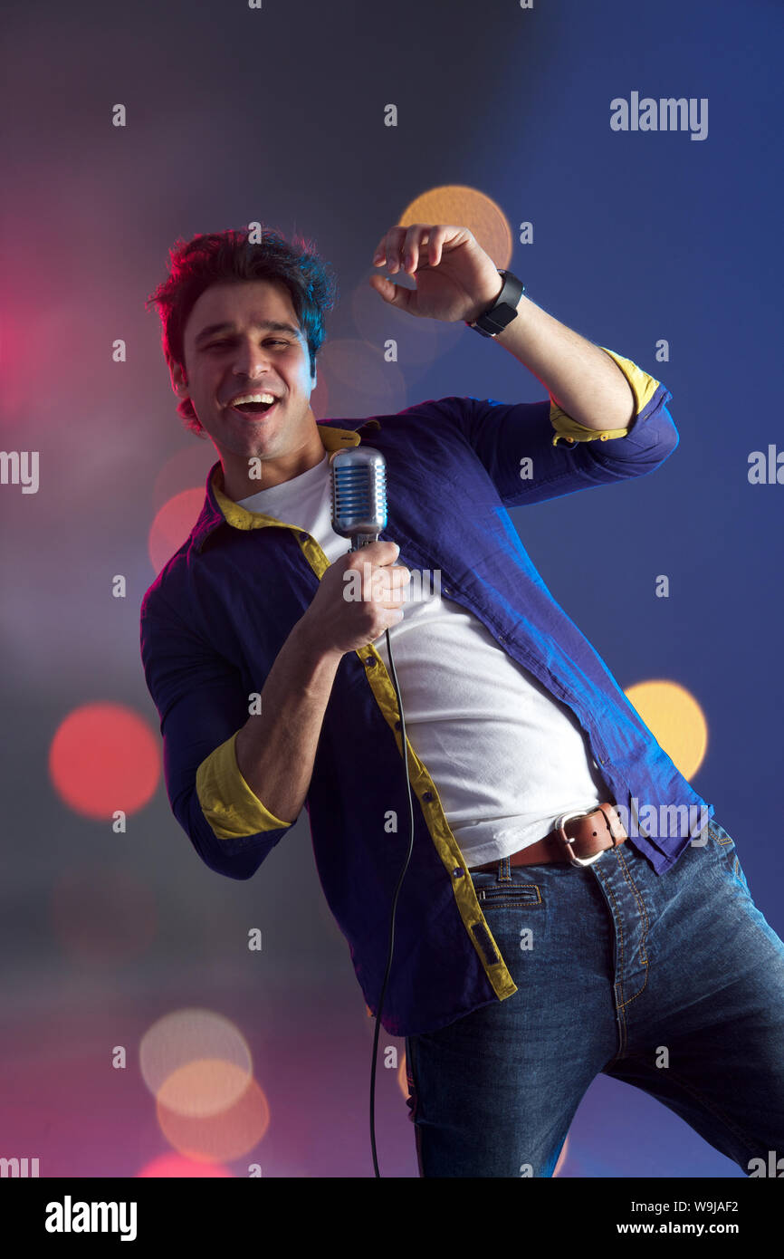 Man singing into microphone and dancing Stock Photo - Alamy
