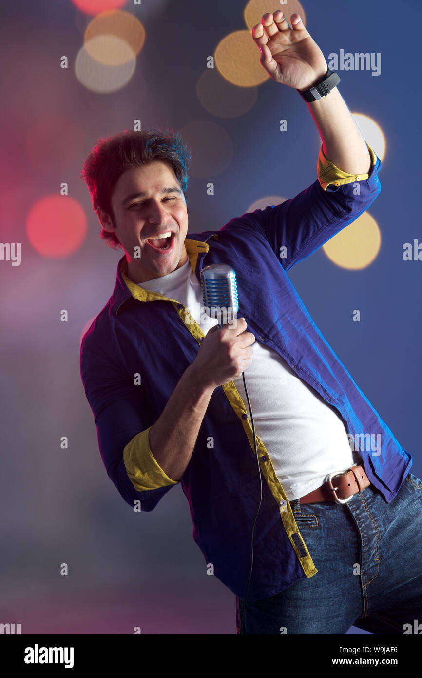 Man singing into microphone and dancing Stock Photo - Alamy