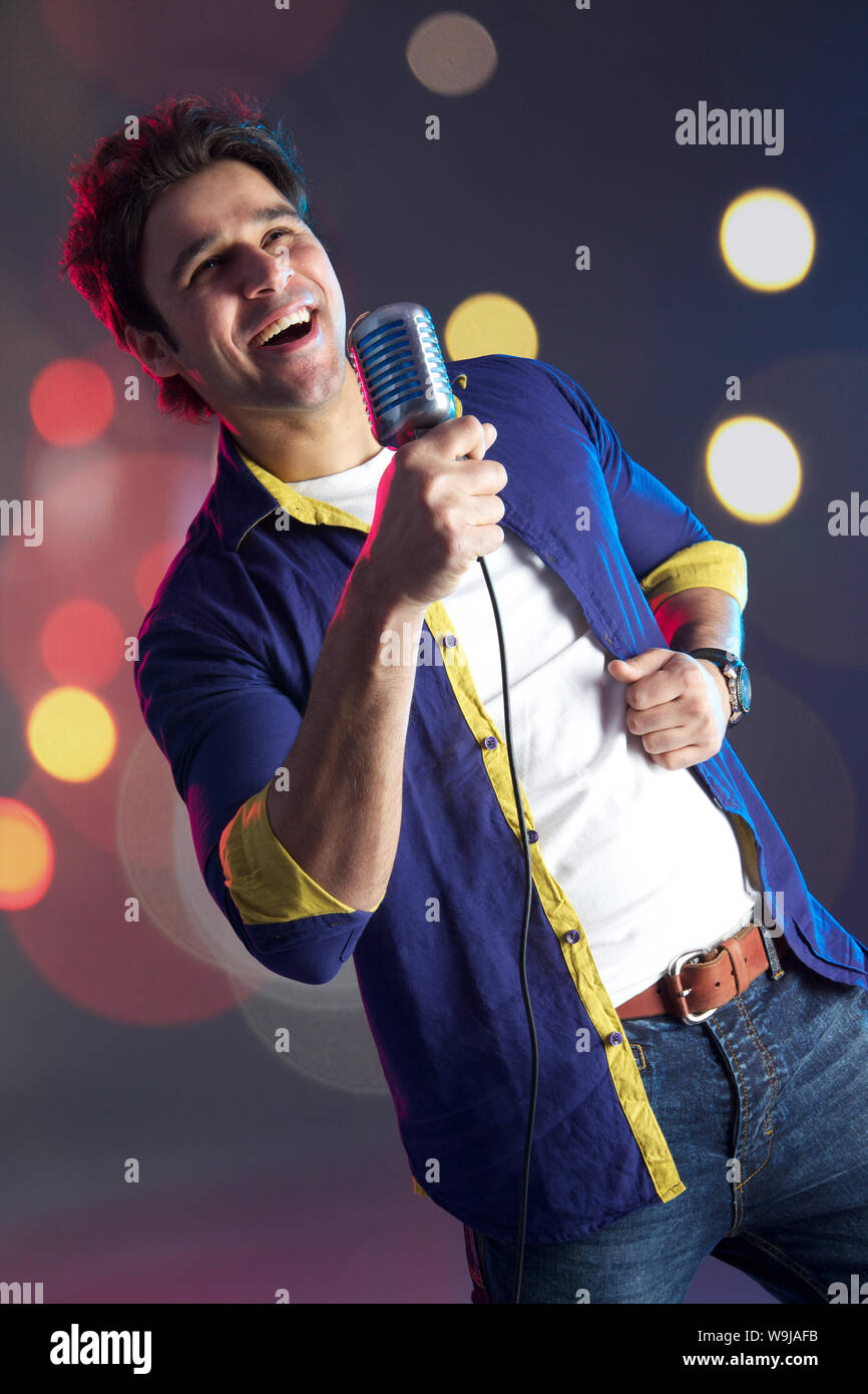 Man singing into microphone and smiling Stock Photo - Alamy