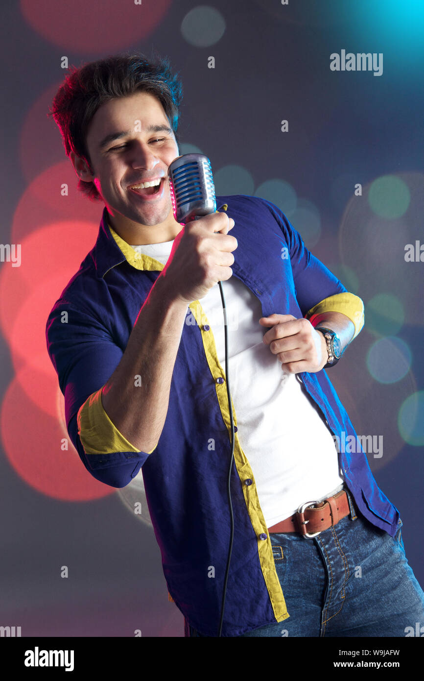 Man singing into microphone and smiling Stock Photo - Alamy