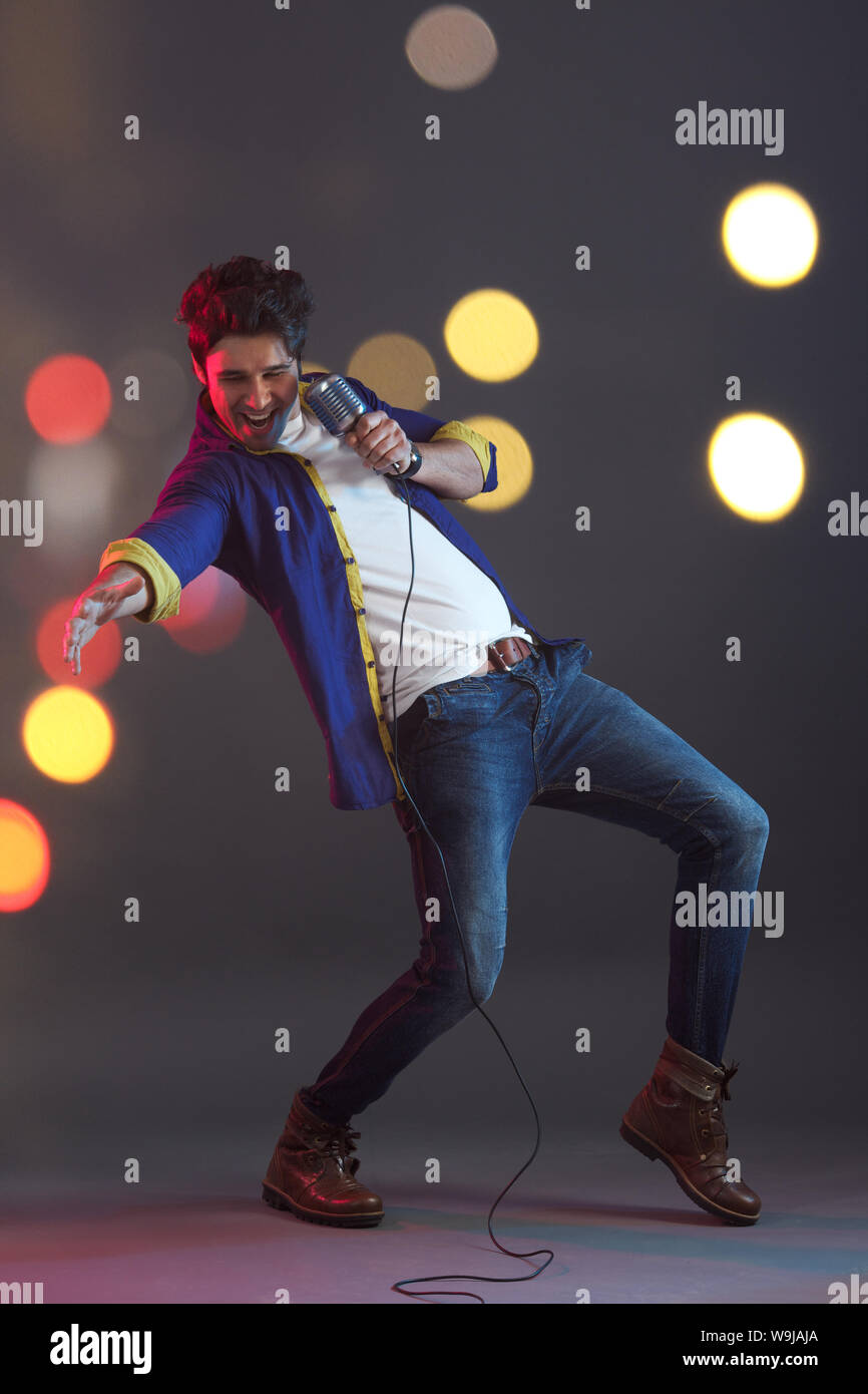 Man singing into microphone and dancing Stock Photo - Alamy