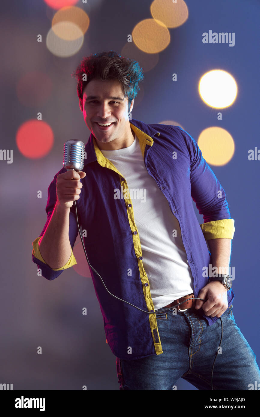 Man singing into microphone and smiling Stock Photo - Alamy