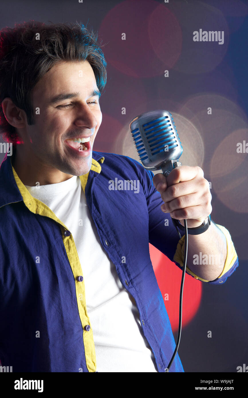 Man singing into microphone and smiling Stock Photo - Alamy