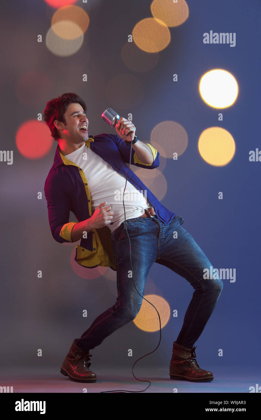 Man singing into microphone and dancing Stock Photo - Alamy
