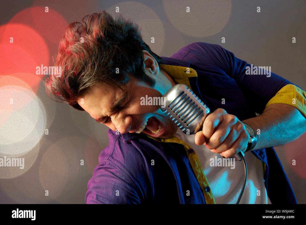 Man singing into microphone Stock Photo - Alamy