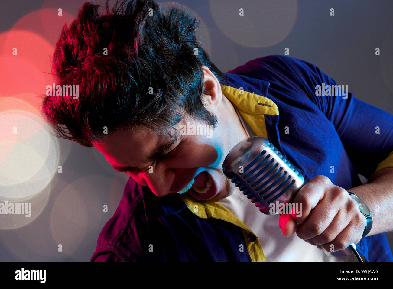 Man singing into microphone Stock Photo - Alamy