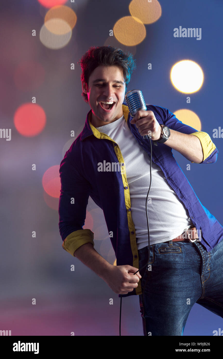 Man singing into microphone and smiling Stock Photo - Alamy