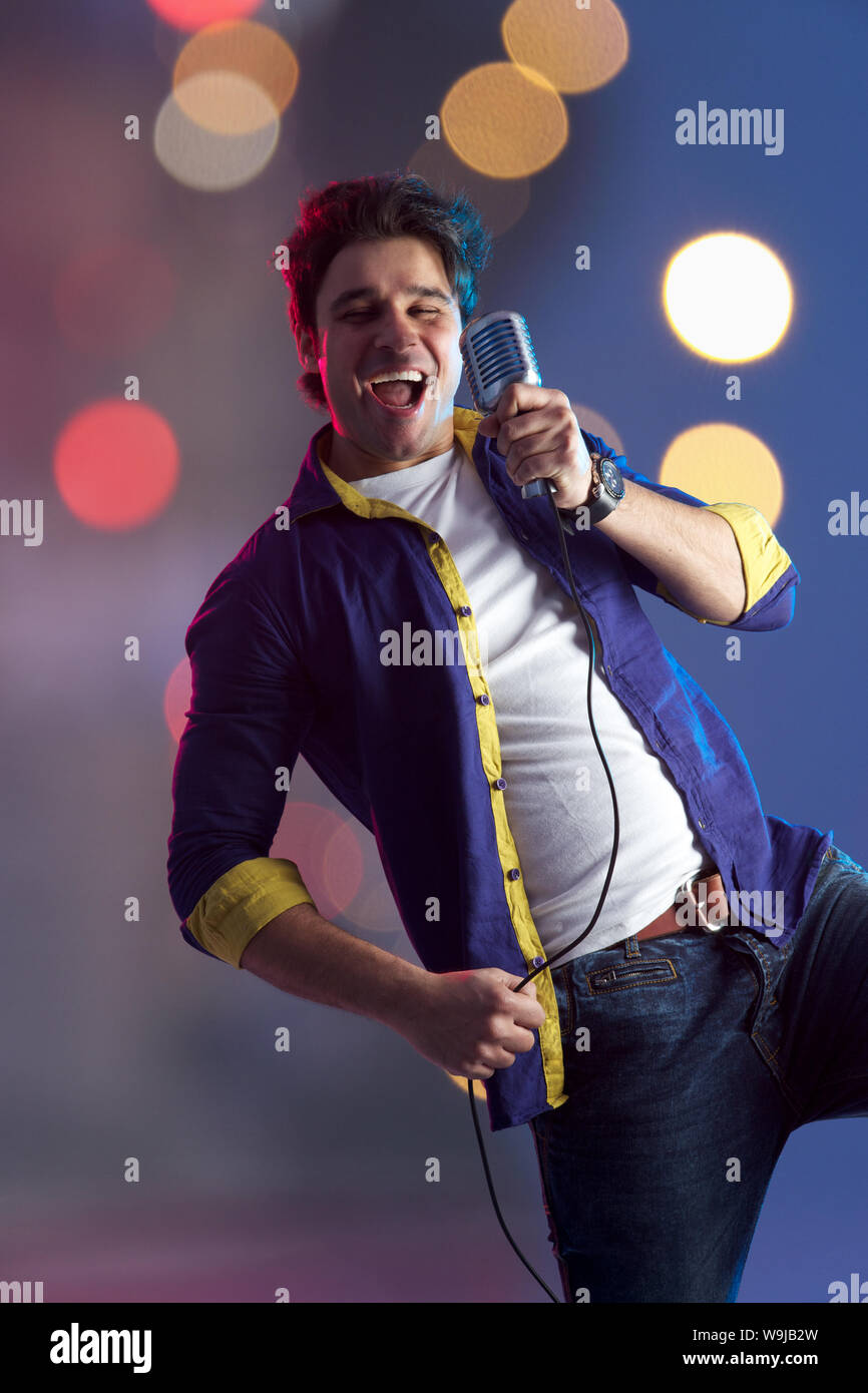 Man singing into microphone and smiling Stock Photo - Alamy