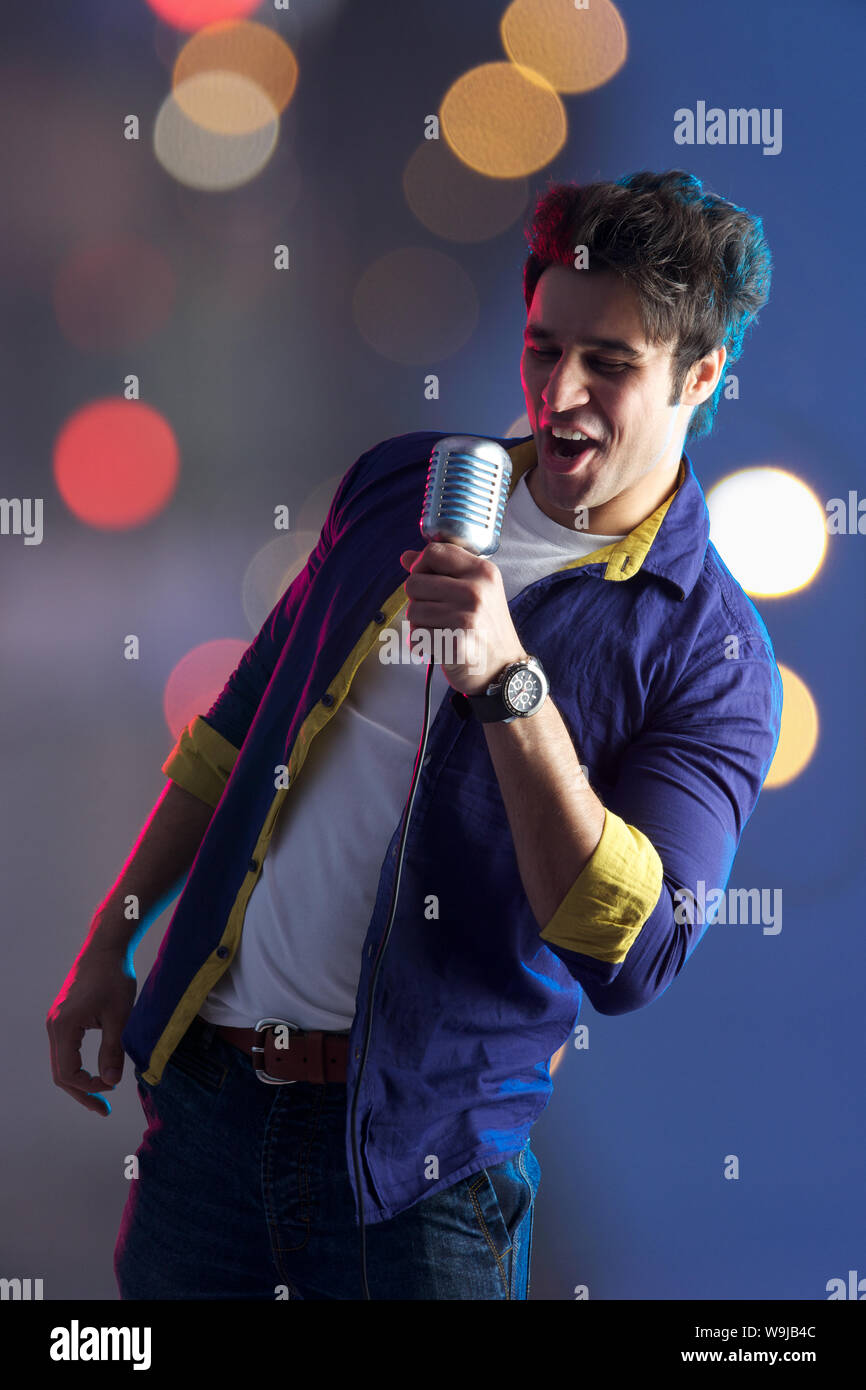 Man singing into microphone and smiling Stock Photo - Alamy