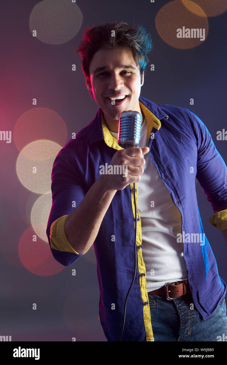 Man singing into microphone and smiling Stock Photo - Alamy