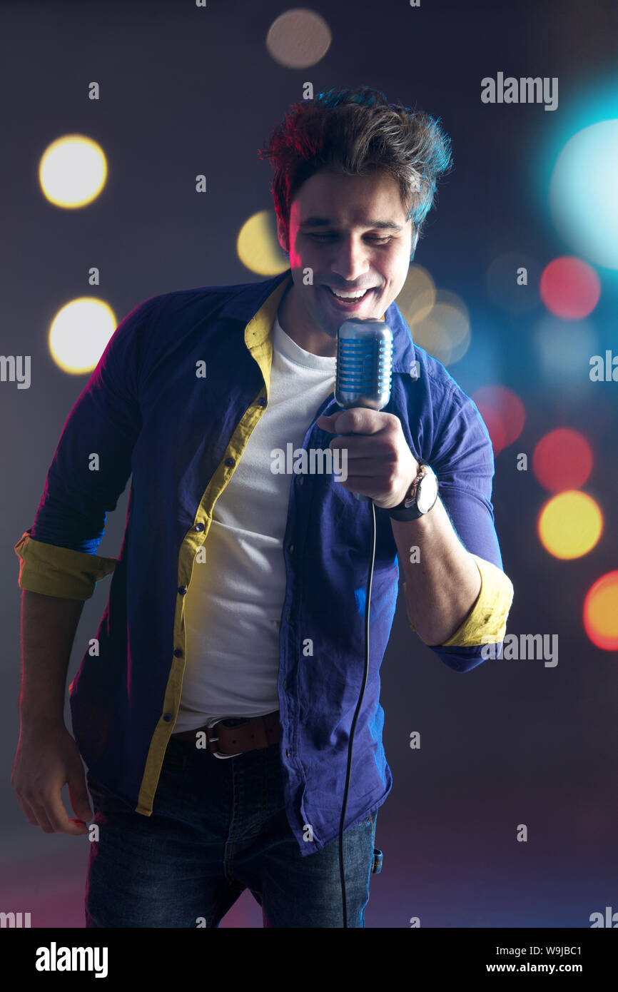 Man singing into microphone and smiling Stock Photo - Alamy