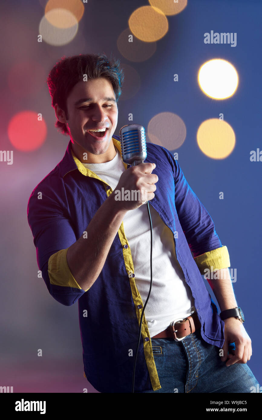 Man singing into microphone and smiling Stock Photo - Alamy