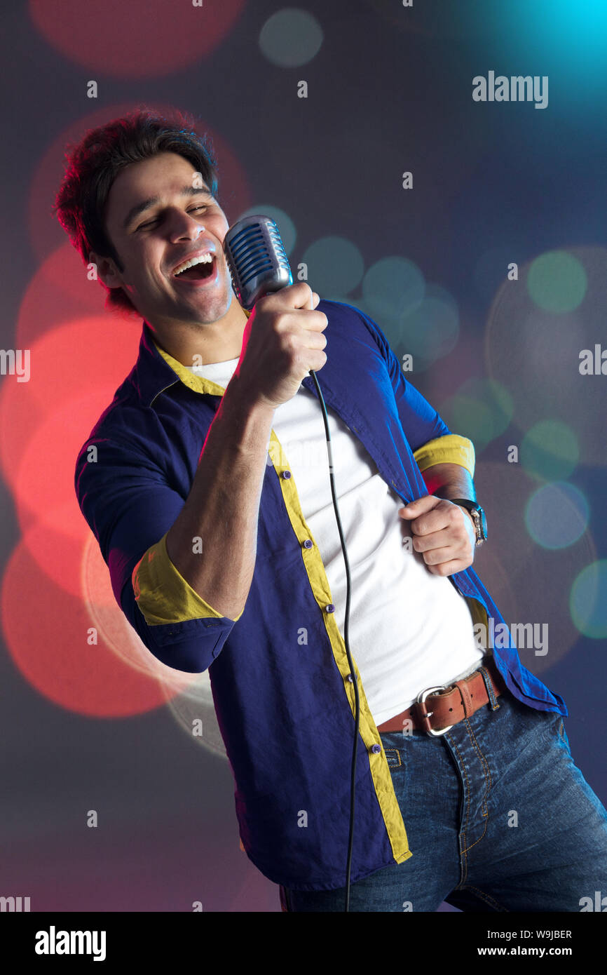 Man singing into microphone and smiling Stock Photo - Alamy