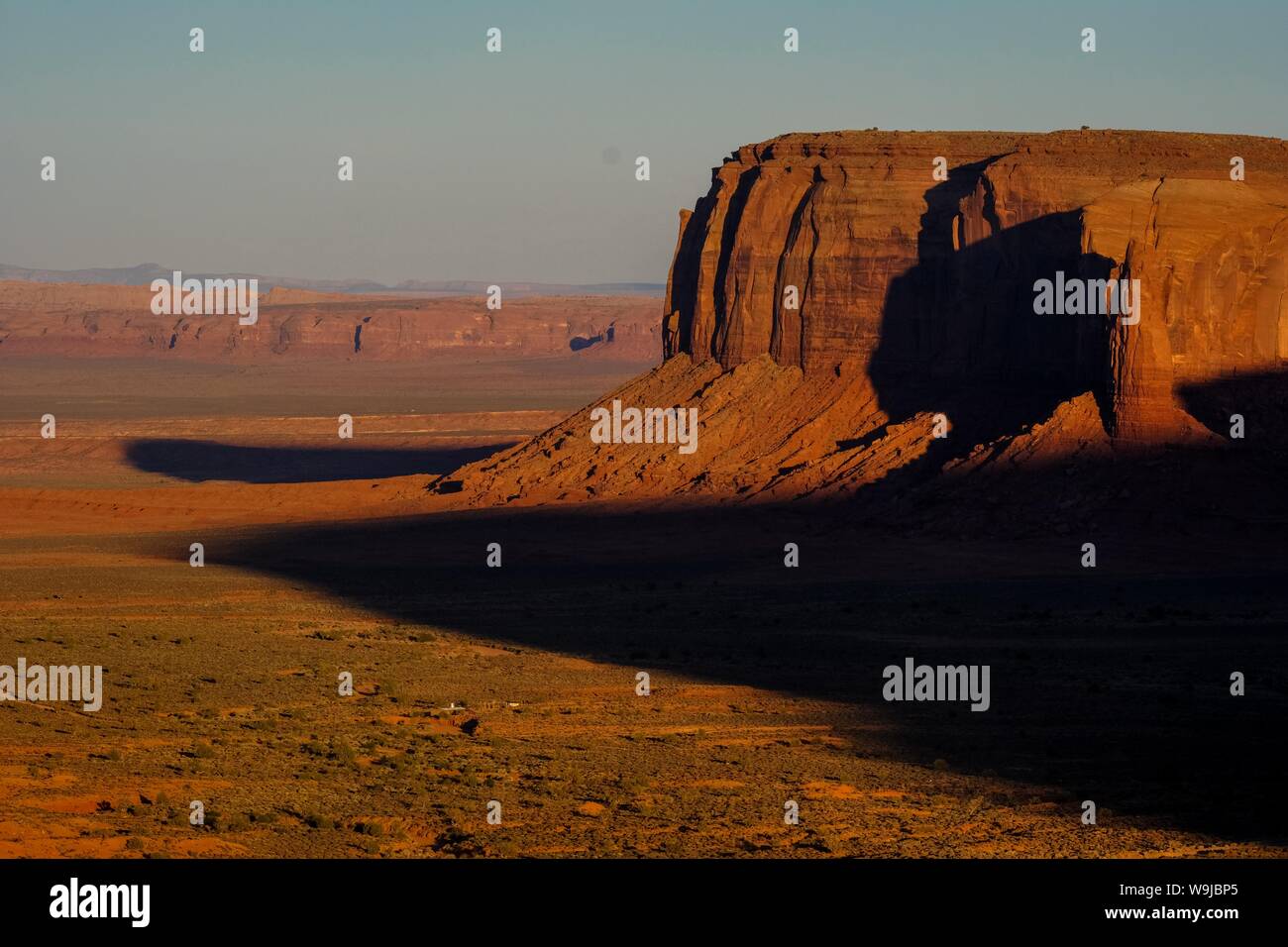 Aerial shot of desert with dried ushes and big cliff in the distance on ...