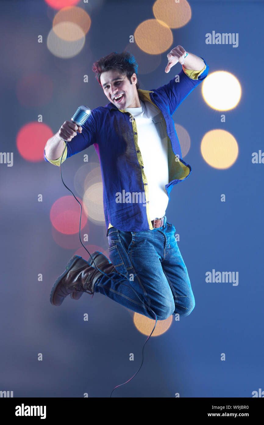 Man singing into microphone and dancing Stock Photo - Alamy
