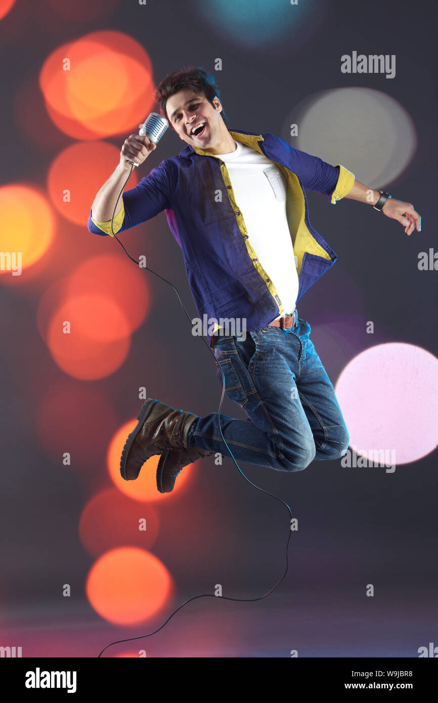 Man singing into microphone and dancing Stock Photo - Alamy