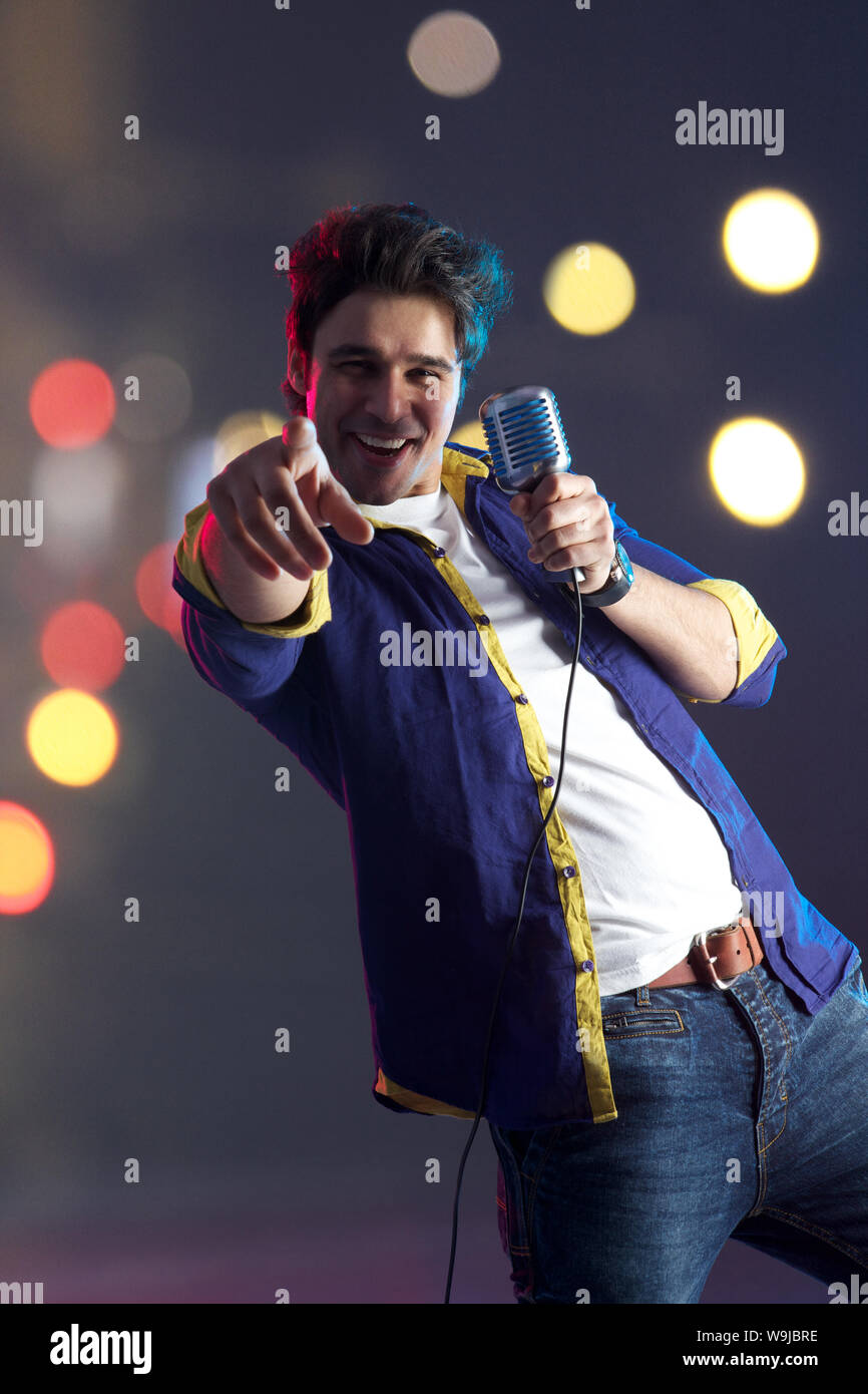 Man singing into microphone and dancing Stock Photo - Alamy