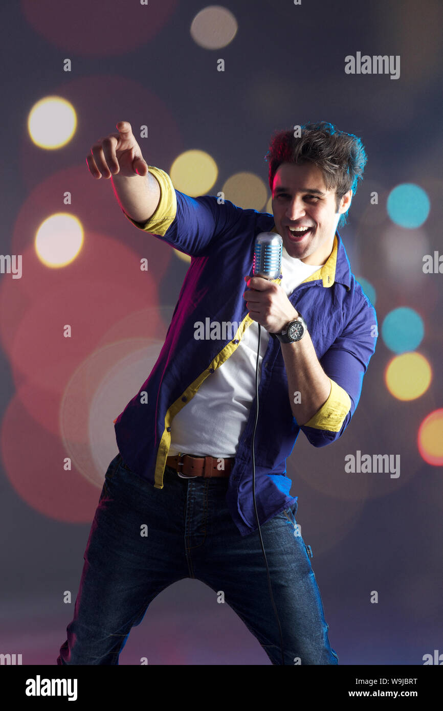 Man singing into microphone and dancing Stock Photo - Alamy