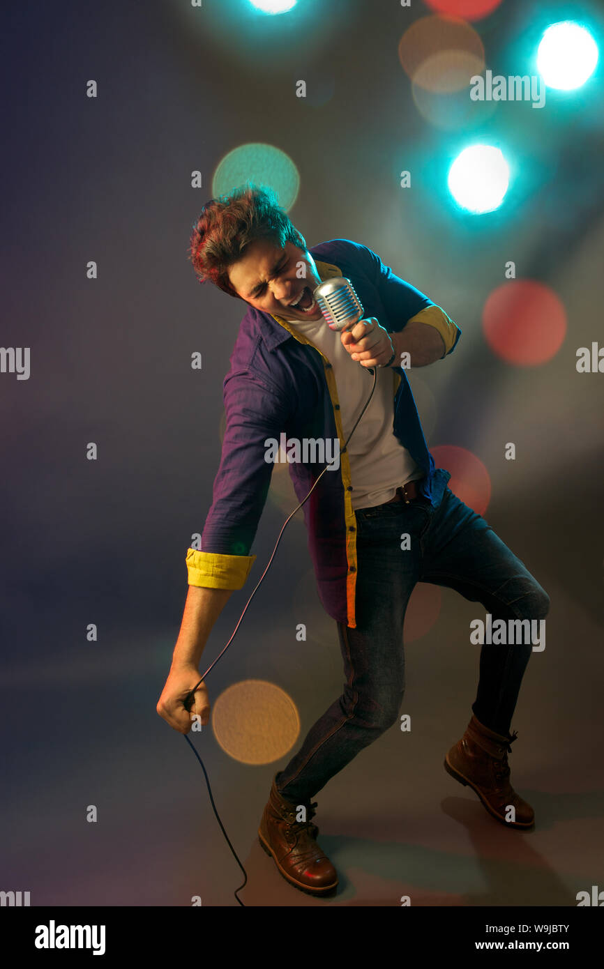 Man singing into microphone Stock Photo - Alamy