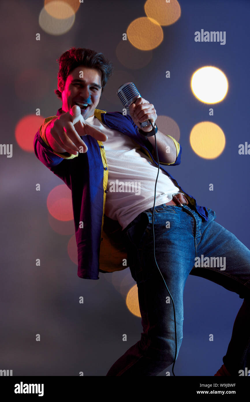 Man singing into microphone and dancing Stock Photo - Alamy