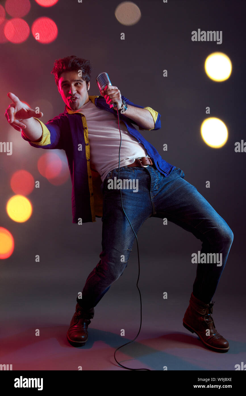 Man singing into microphone and dancing Stock Photo - Alamy