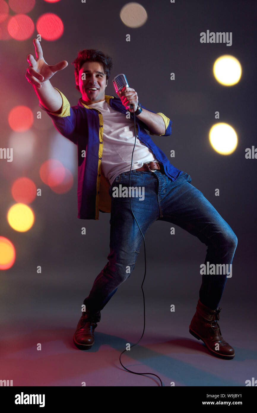 Man singing into microphone and dancing Stock Photo - Alamy