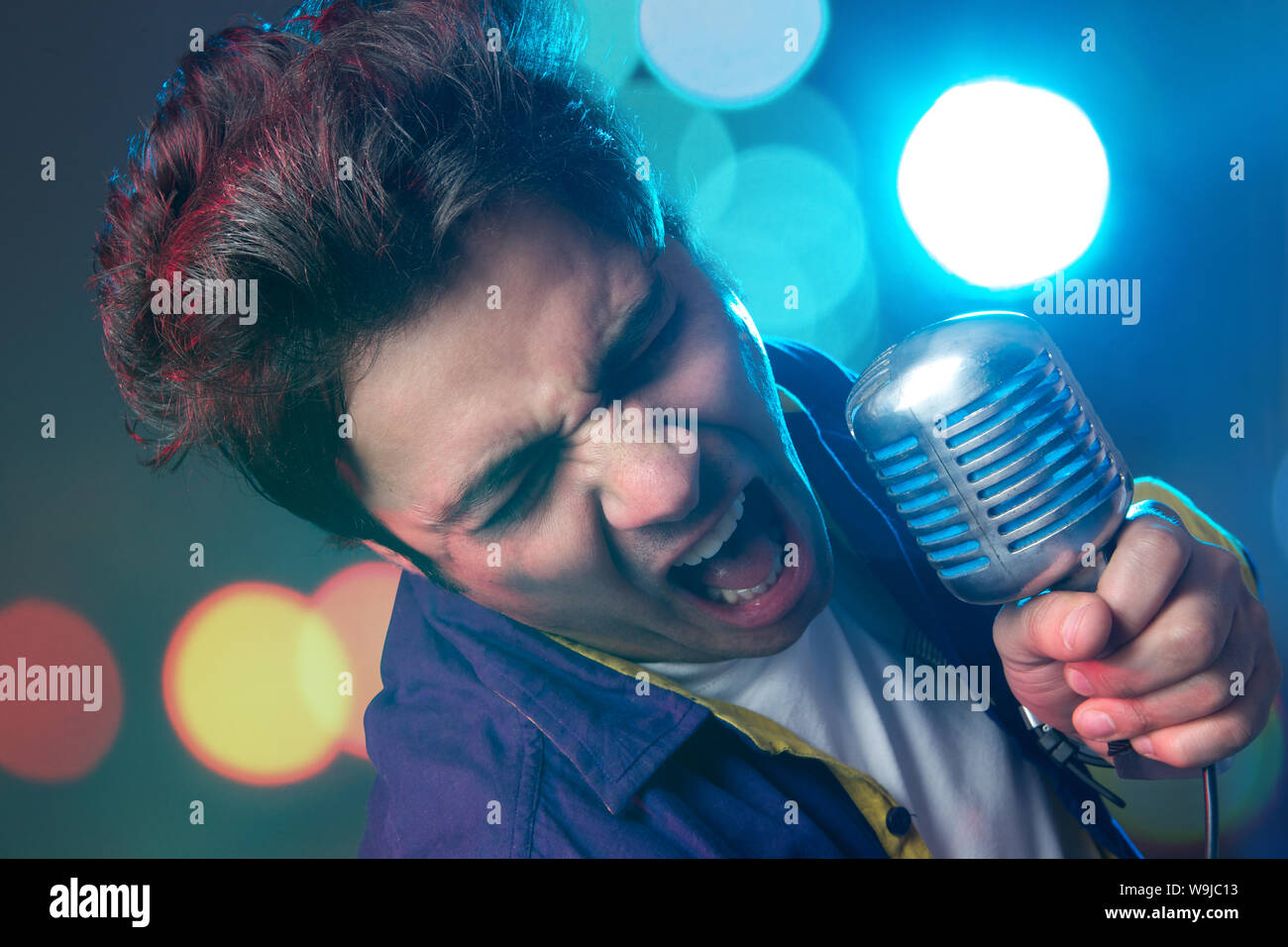Man singing into microphone Stock Photo - Alamy