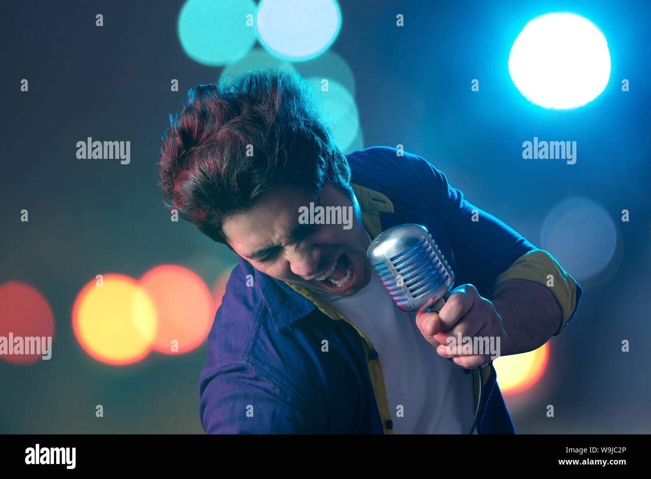 Man singing into microphone Stock Photo - Alamy