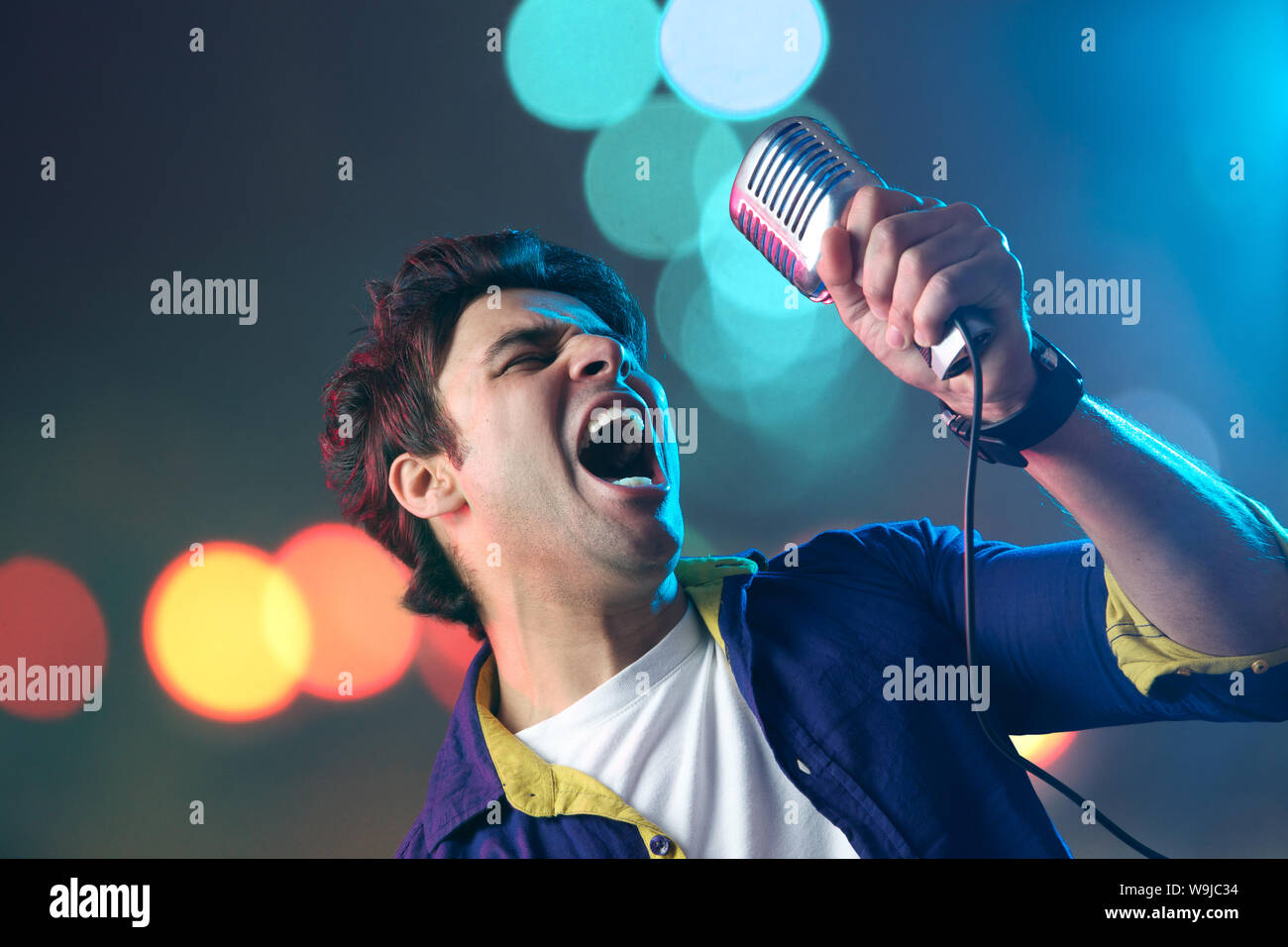 Man singing into microphone Stock Photo - Alamy