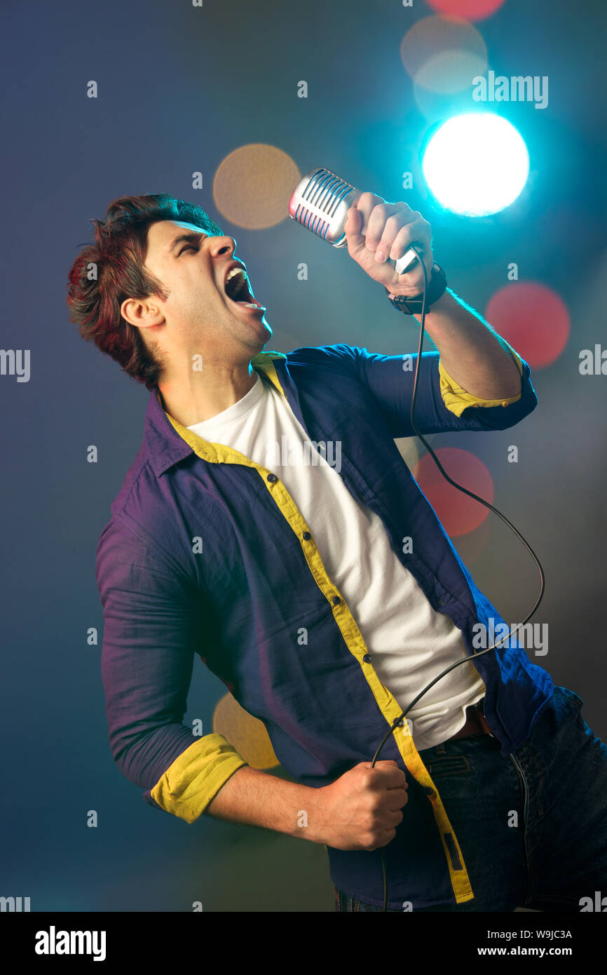 Man singing into microphone Stock Photo - Alamy