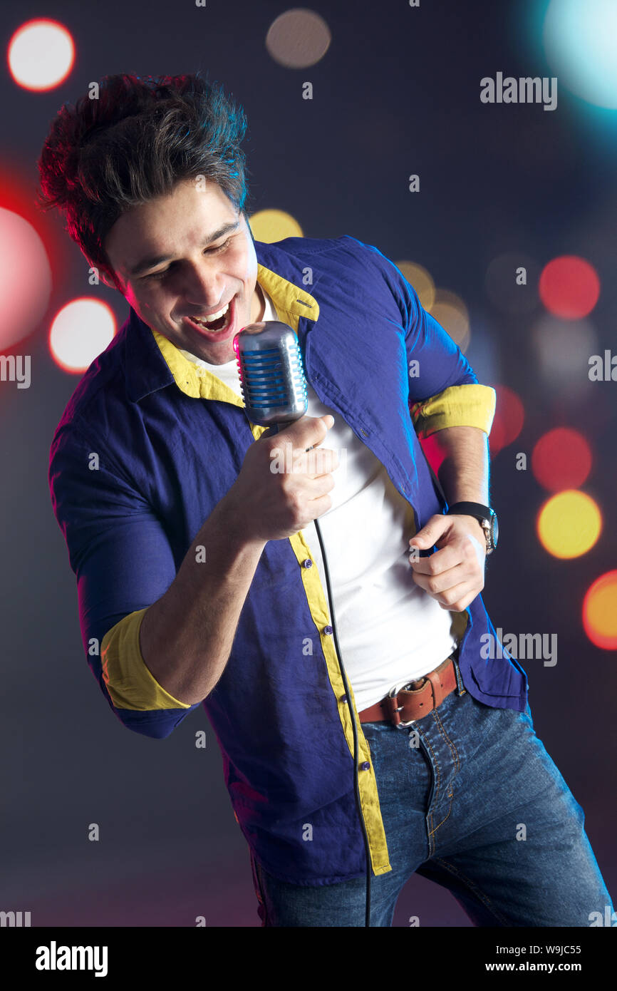 Man singing into microphone and smiling Stock Photo - Alamy