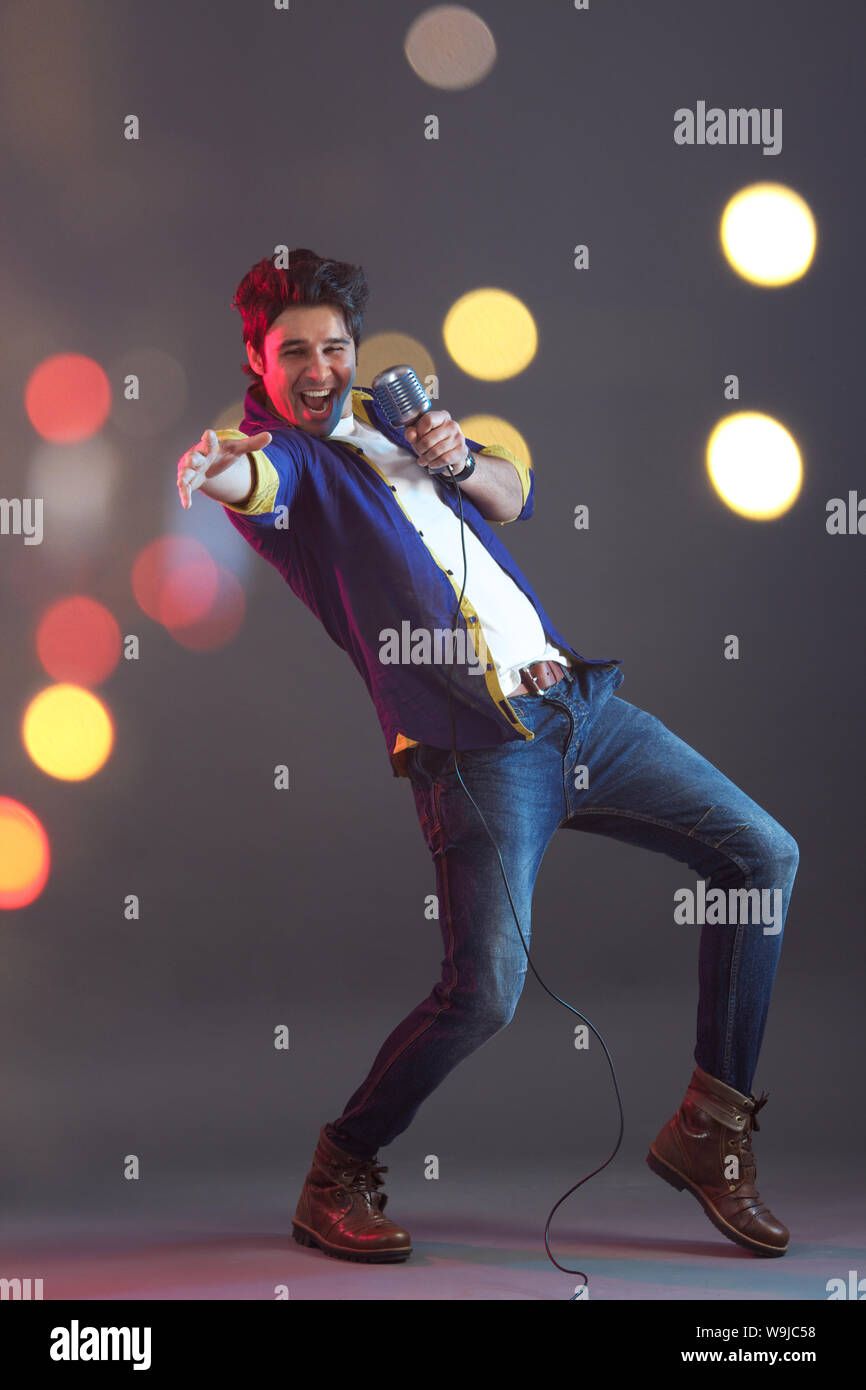 Man singing into microphone and dancing Stock Photo - Alamy