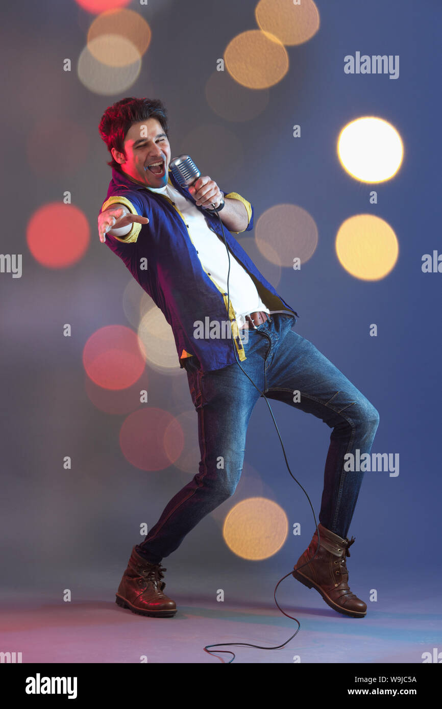 Man singing into microphone and dancing Stock Photo - Alamy