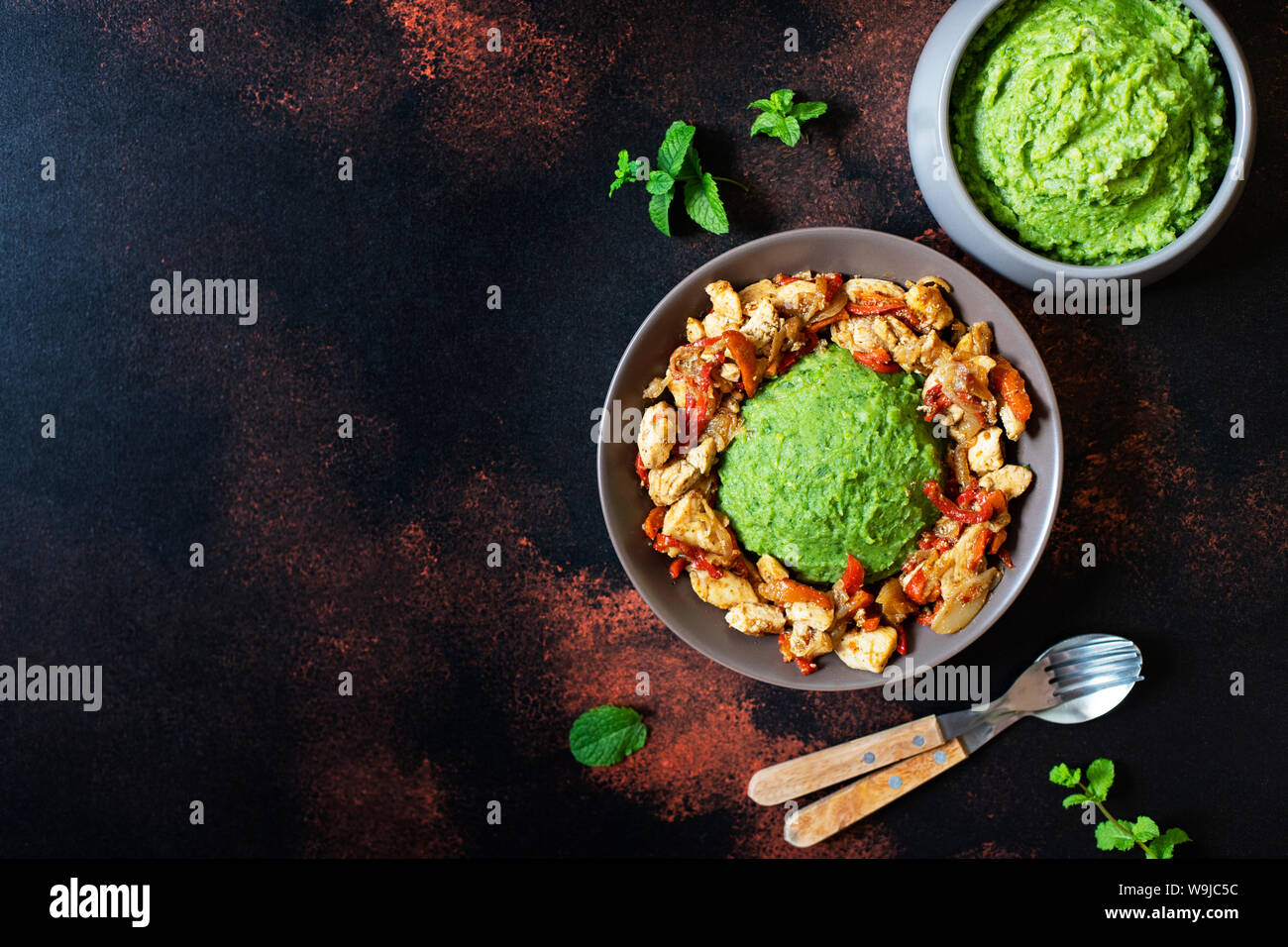 Mashed potatoes with green peas and corn served with chicken and ...