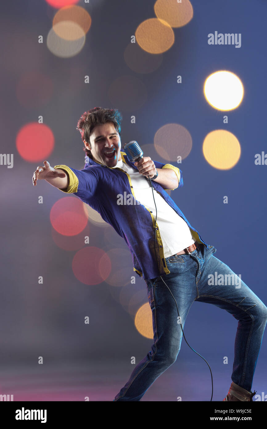 Man singing into microphone and dancing Stock Photo - Alamy