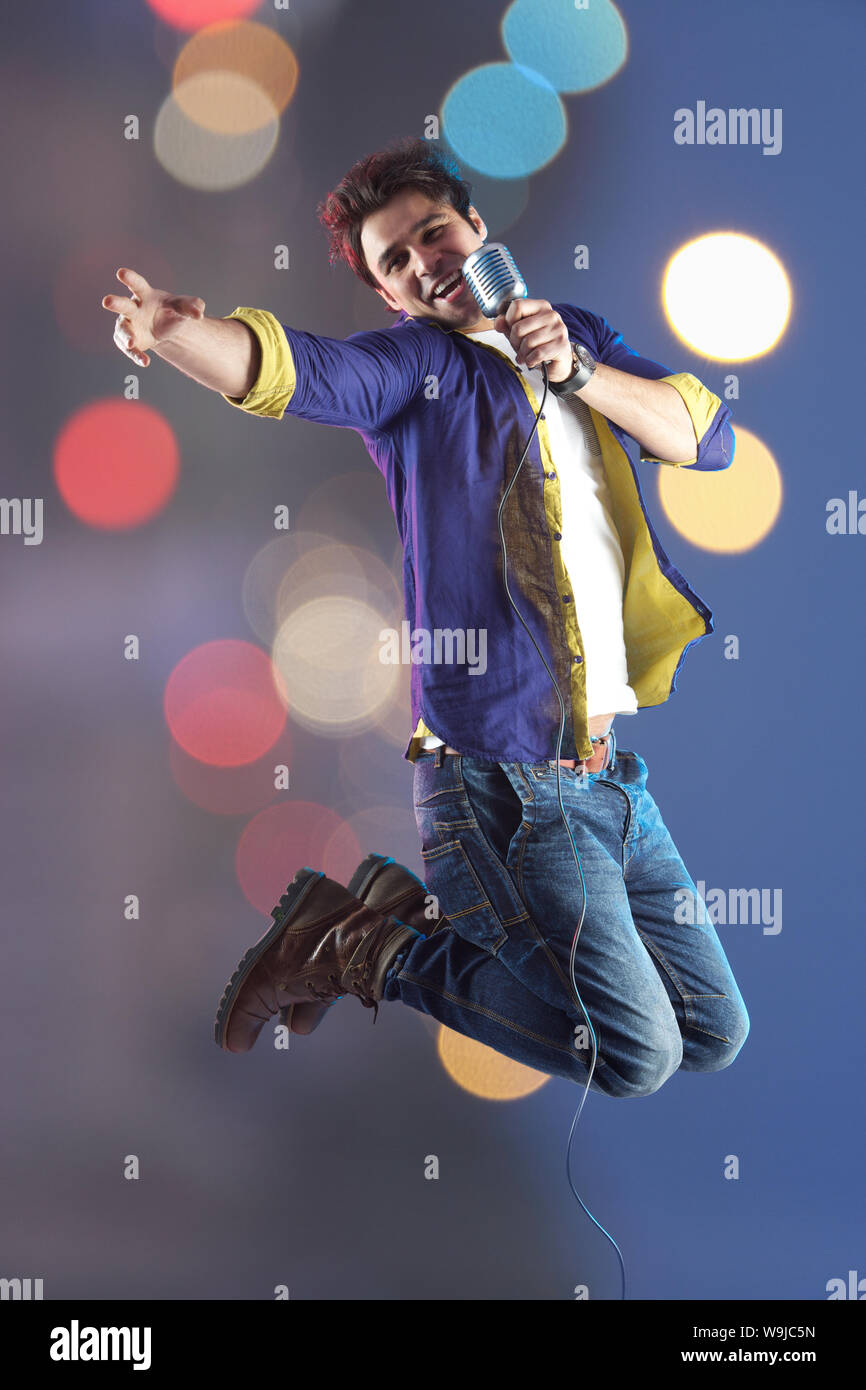 Man singing into microphone and dancing Stock Photo - Alamy