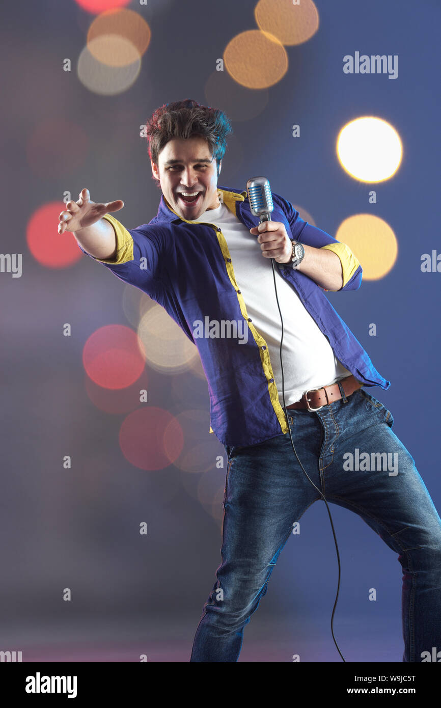 Man singing into microphone and dancing Stock Photo - Alamy