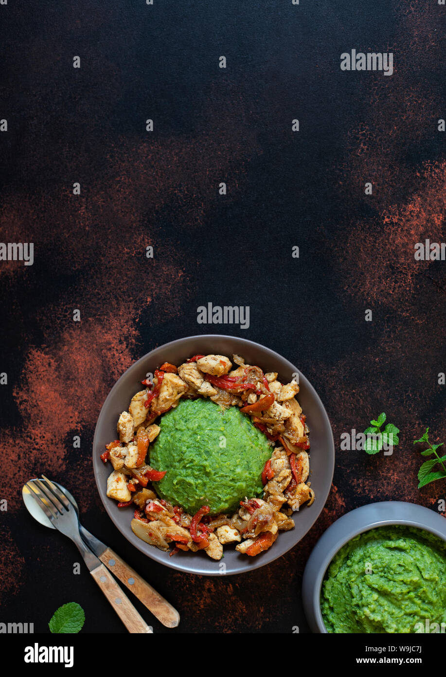 Mashed potatoes with green peas and corn served with chicken and ...