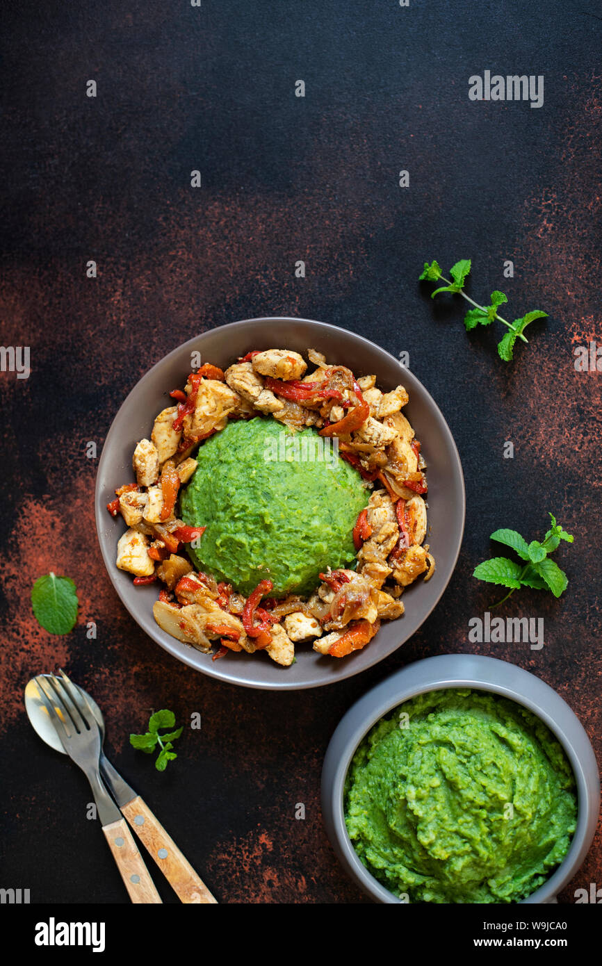 Mashed potatoes with green peas and corn served with chicken and ...