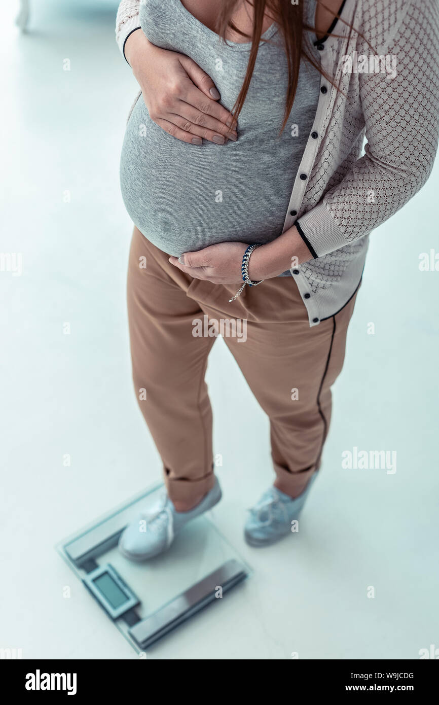 Young pregnant female person standing on weights Stock Photo - Alamy