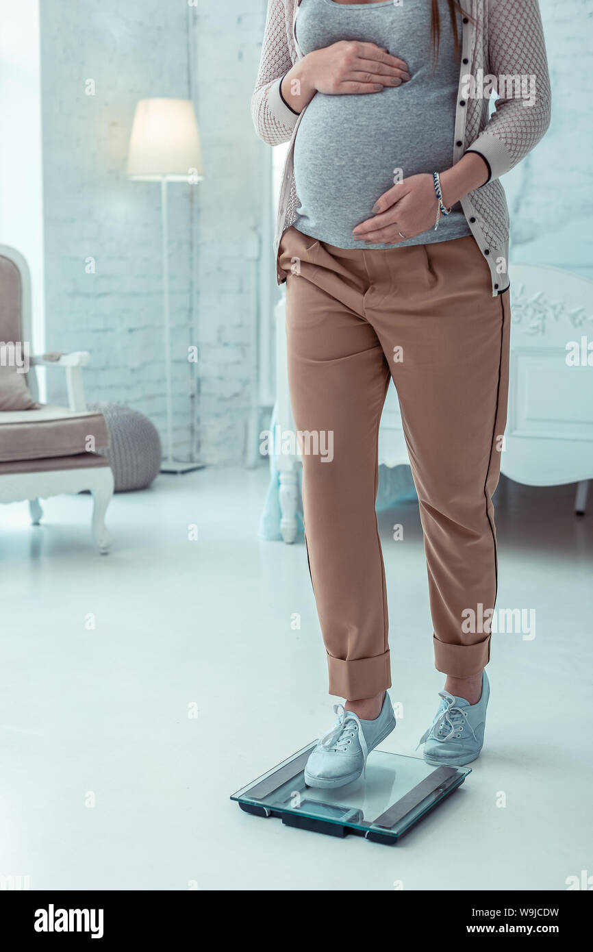 Healthy pregnancy checking her weight with baby belly Stock Photo - Alamy