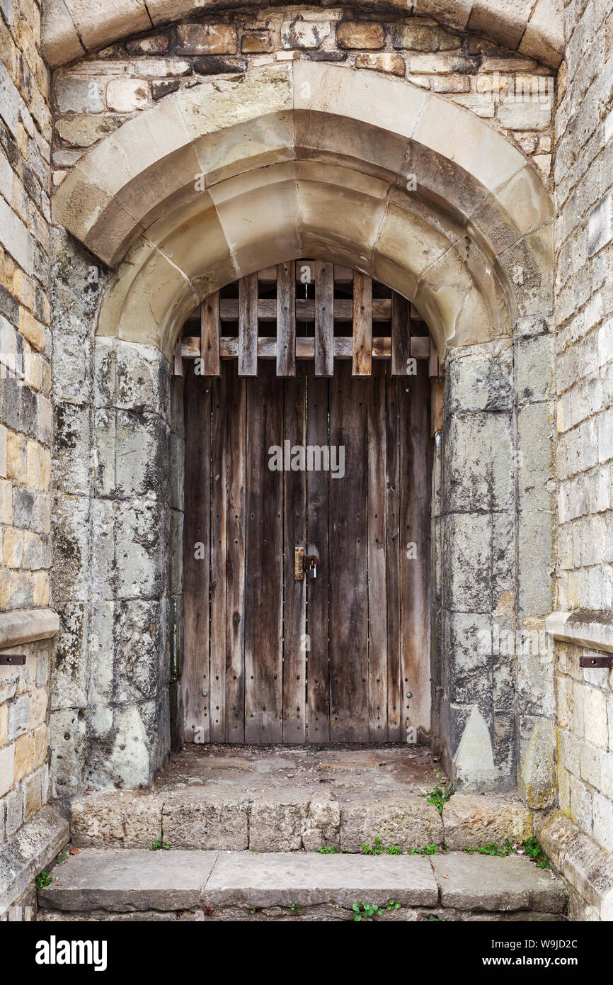 Locked wooden door in old fortification wall, background photo texture ...