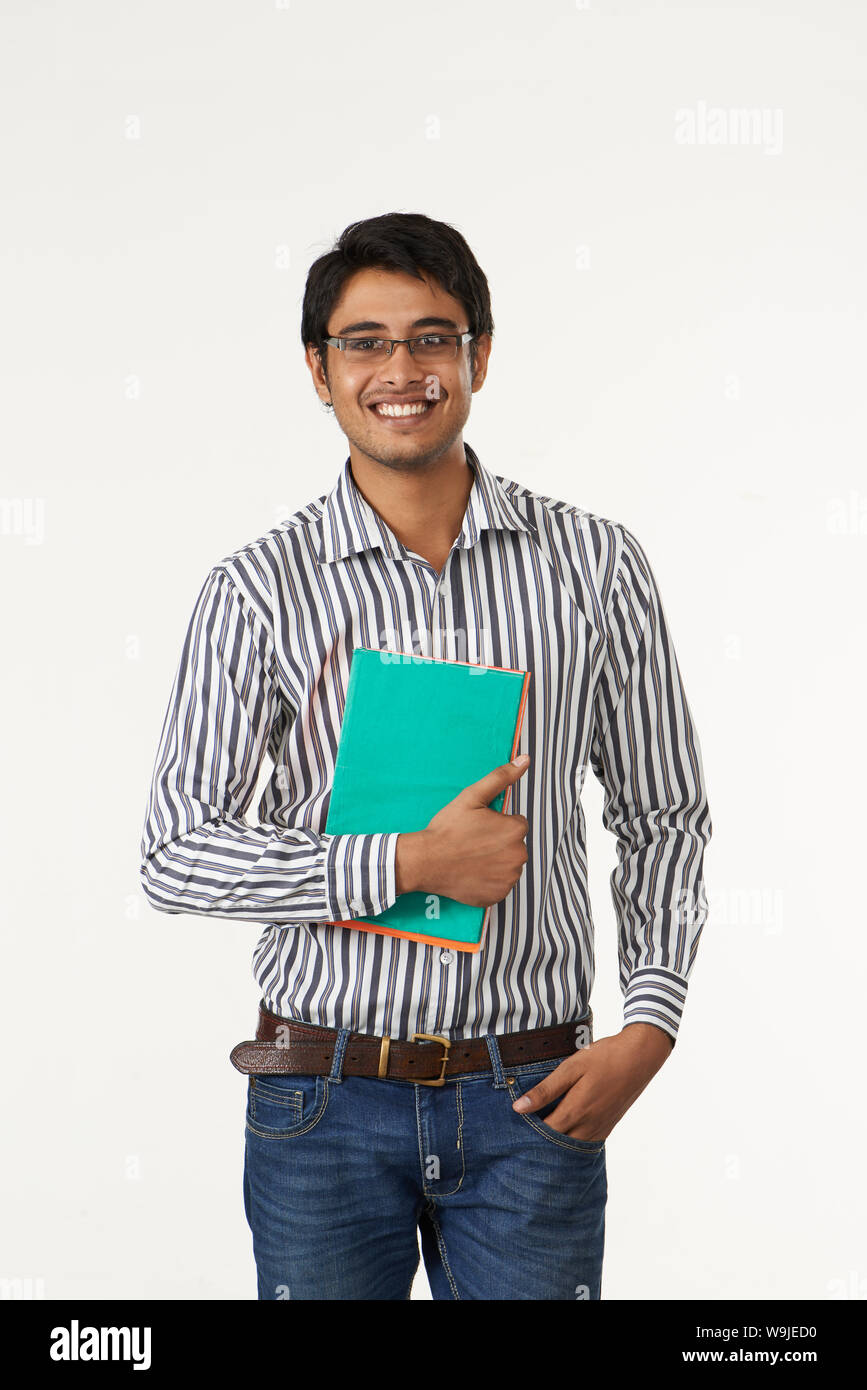 College student holding books and smiling Stock Photo - Alamy