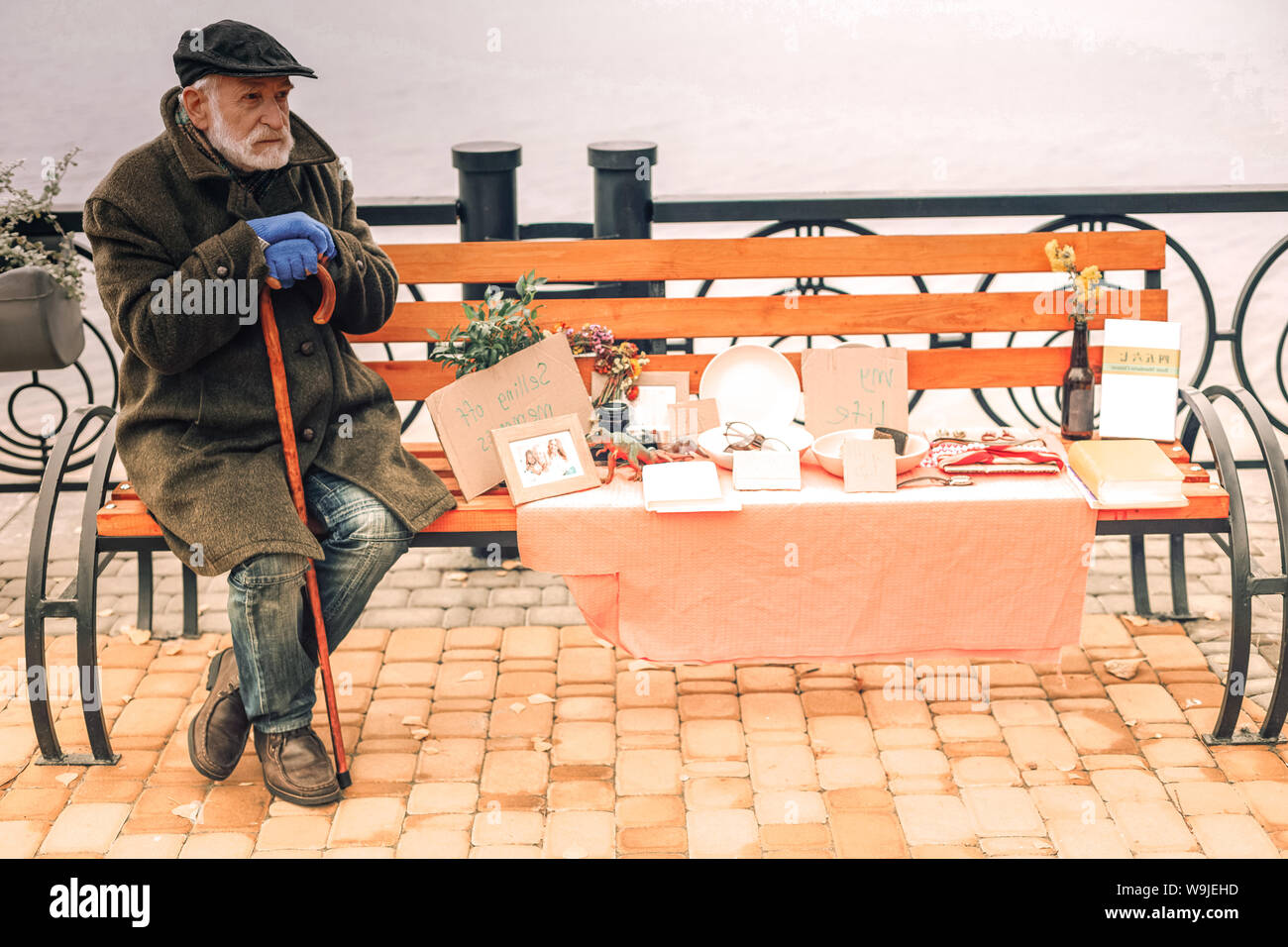 Lonely poor man with cane selling stuff in park Stock Photo - Alamy