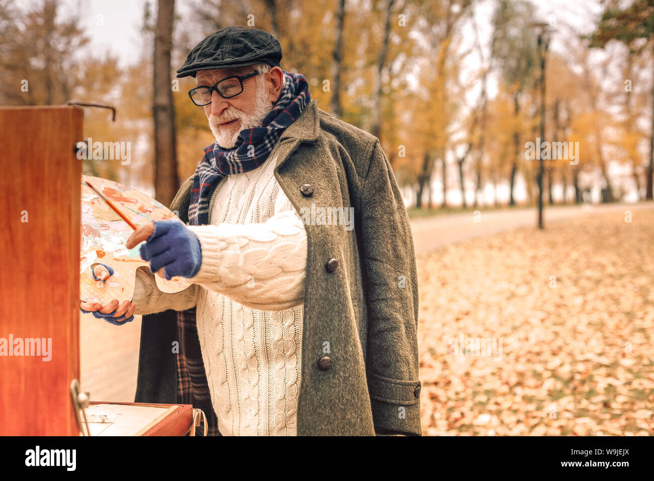 Senior man drawing a painting in park Stock Photo - Alamy