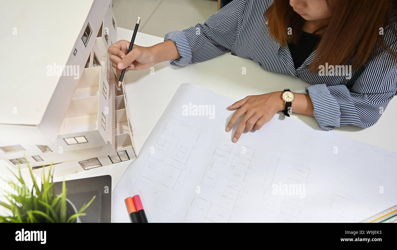 Top view architect working with model house and blueprint in home ...