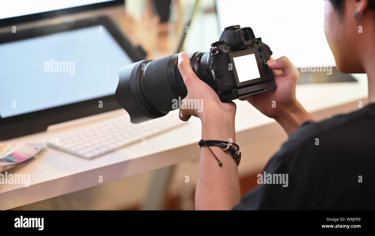 A Man photographer using professional camera and blank screen display ...