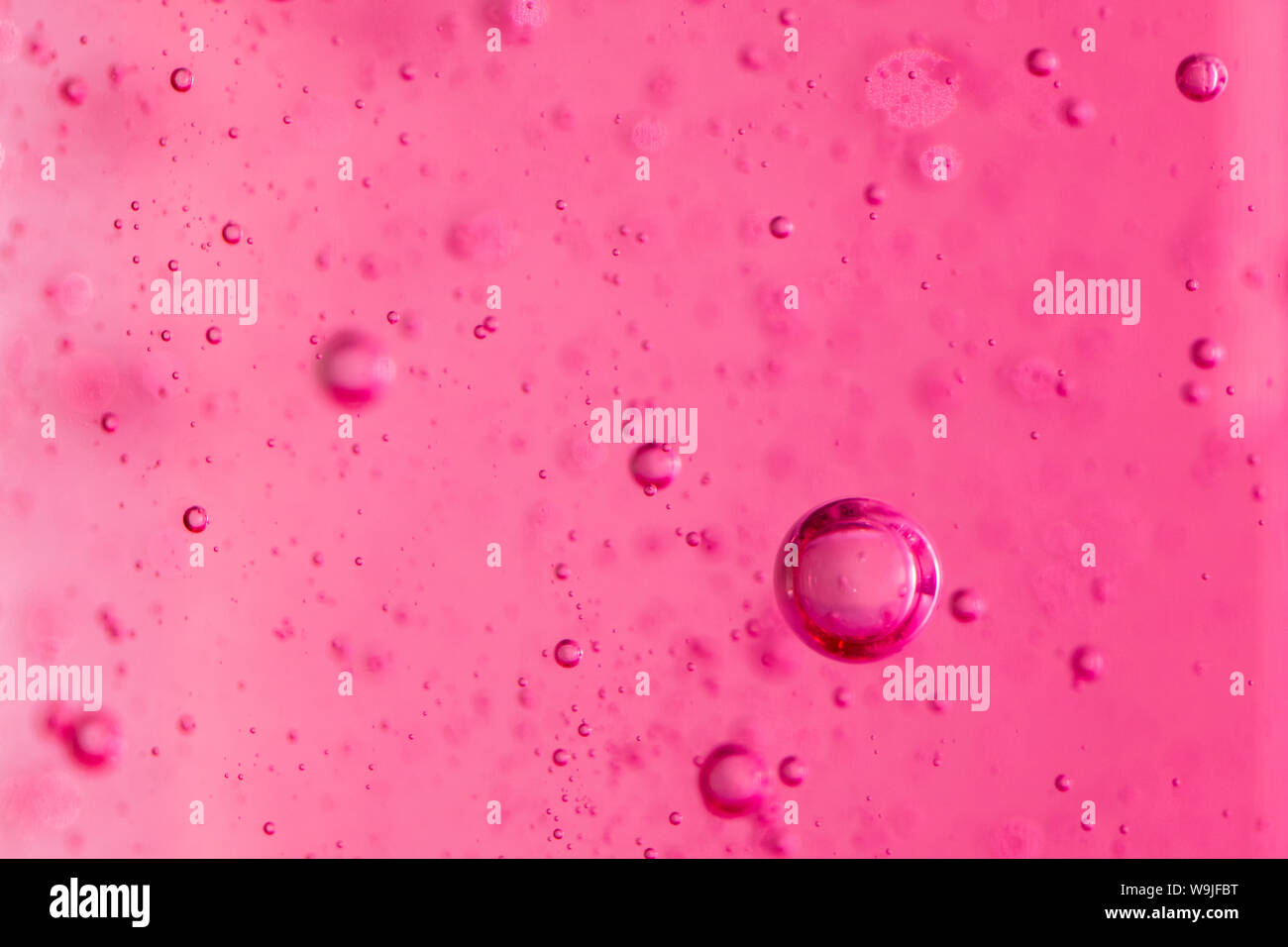 Macro Oxygen bubbles in water on a pink background, concept such as ...